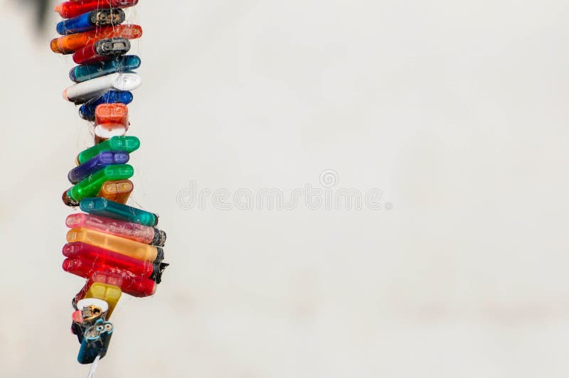 Colorful Stack of Plastic Caps Hanging on a String Against a Plain ...