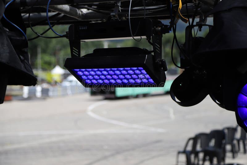 Colorful Stage Lighting Setup for an Outdoor Event with Chairs Arranged ...