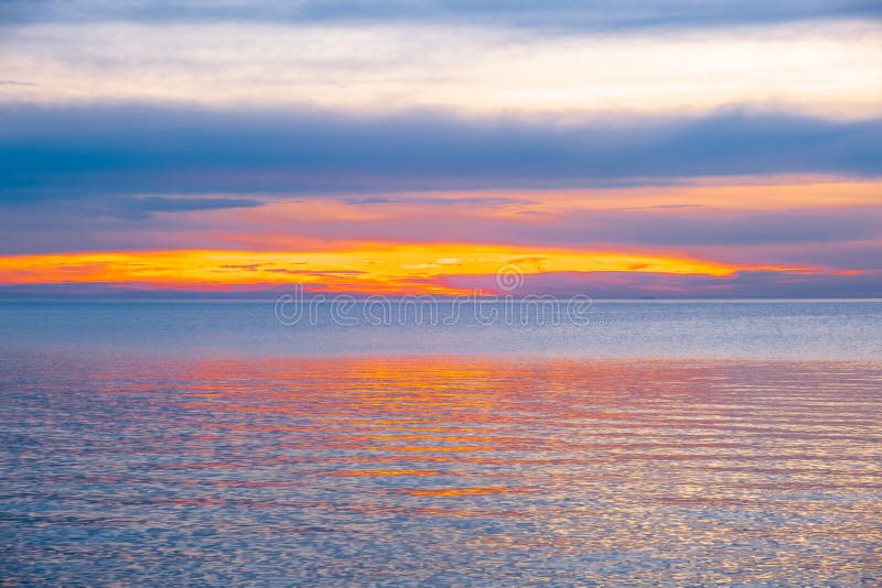Colorful Sunset Over Water with Seagulls on Rocks. Stock Photo - Image ...