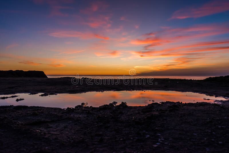 Reflection in a Puddle of Colorful Sunset by the Sea Stock Photo ...