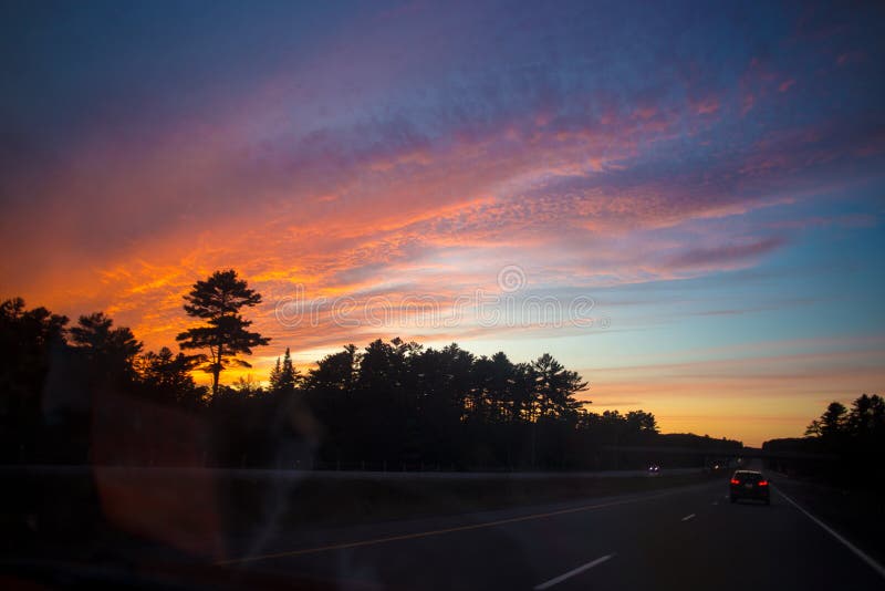 Colorful Sunset Sky Over a Highway Lined with Trees Stock Photo - Image ...