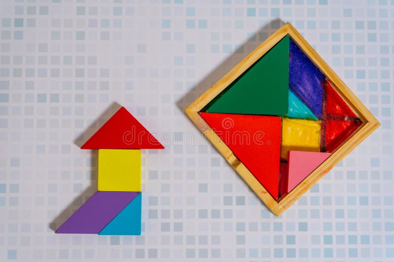 Colorful Tangram Puzzle Forming a Figure with Its Container on a Wooden ...