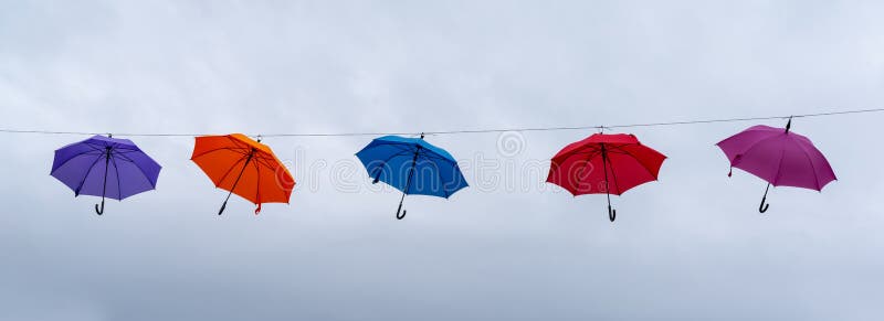 Colorful Umbrellas Hanging on a Cable Underneath an Expressive Overcast ...