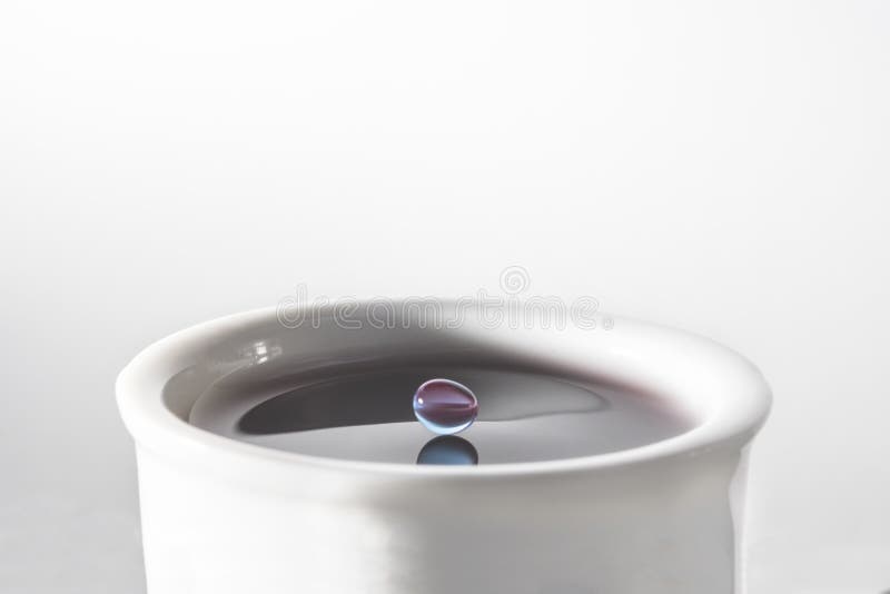 Colorful Water Droplet Balancing on Cup of Water Stock Photo - Image of ...