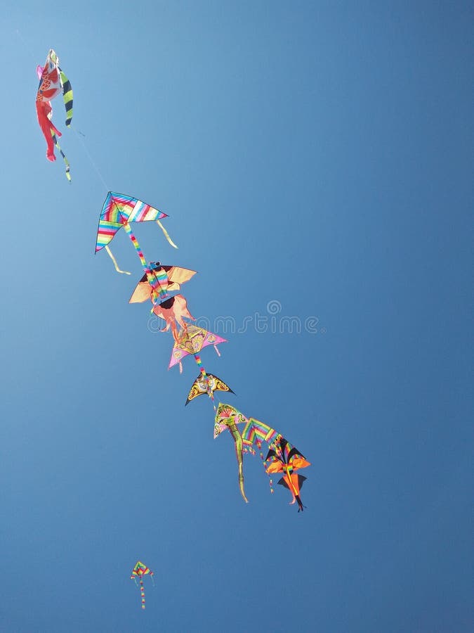 Coloured Kites Flying at Wind in the Blue Sky Guided by Childrens Stock ...