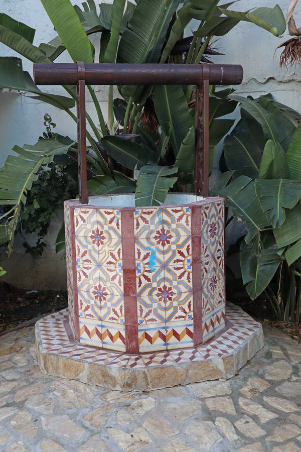 A Colourful Ceramic Artwork of a Water Well, Set in a Leafy Corner in ...
