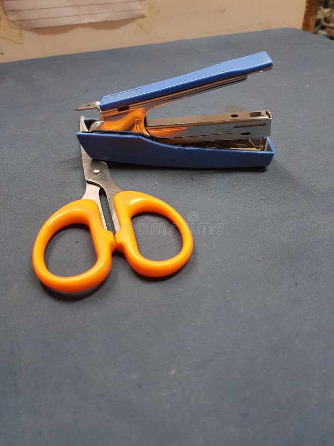 A Combo of Stapler and Scissors Showing Its Attraction on Roof Table. I ...