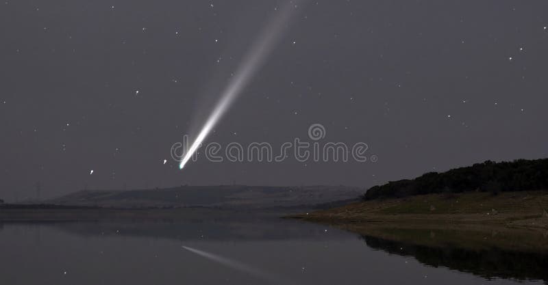 A Comet with an Intense Coma and a Long Tail Over a Lake and an ...