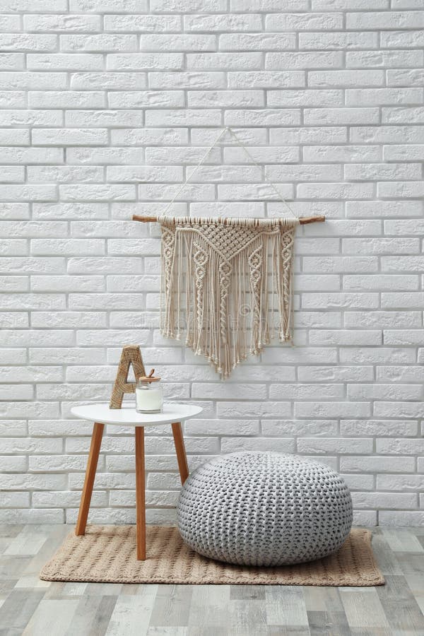 Comfortable Knitted Pouf, Table and Decor Elements Near White Brick ...
