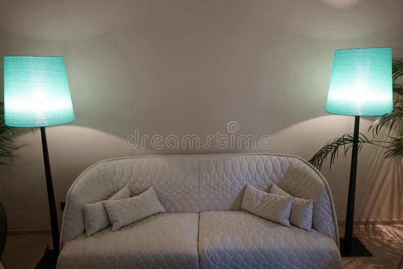 Comfortable Looking White Couch between Two Lit Lamps in a Living Room ...