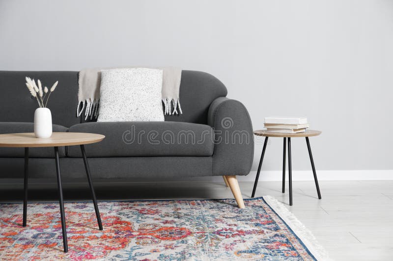 Comfortable Sofa and Tables Near Grey Wall in Room Stock Image - Image ...