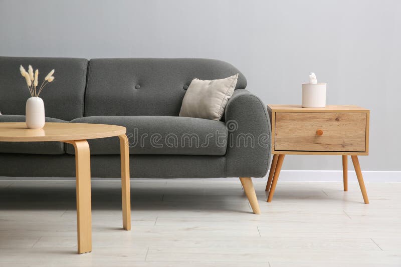 Comfortable Sofa and Tables Near Grey Wall in Room Stock Image - Image ...