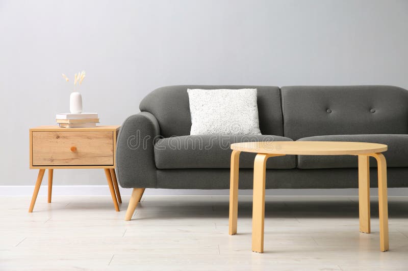 Comfortable Sofa and Tables Near Grey Wall in Room Stock Photo - Image ...