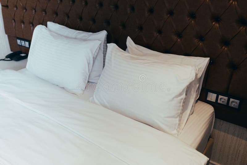 Comfortable Soft Pillows on the Bed. Close-up White Bedding Sheets and ...