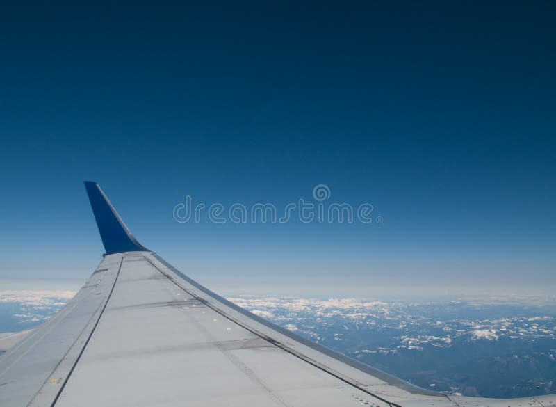 Commercial Jetliner Wing Above Clouds and Mountain Stock Image - Image ...