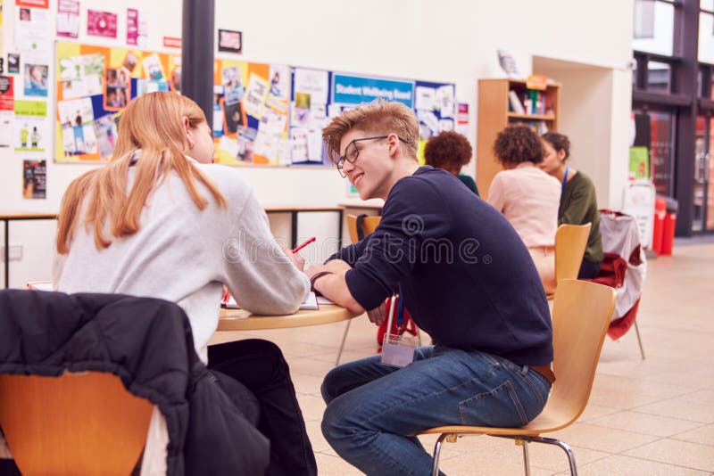 Communal Area of Busy College Campus with Students Working at Tables ...