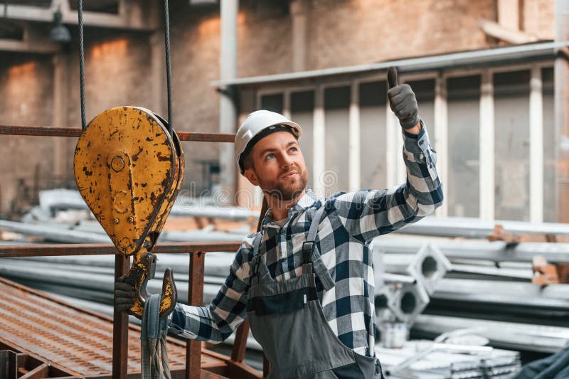 Communicate with Crane Operator. Factory Male Worker in Uniform is ...