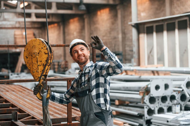 Communicate with Crane Operator. Factory Male Worker in Uniform is ...