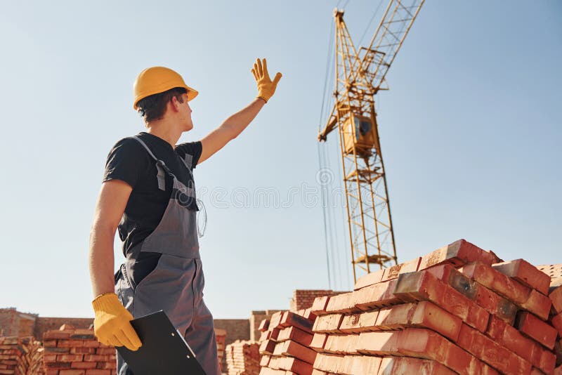 Communicating with Crane Guy. Construction Worker in Uniform and Safety ...