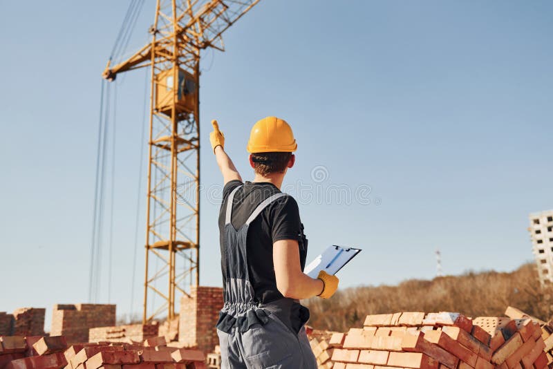Communicating with Crane Guy. Construction Worker in Uniform and Safety ...