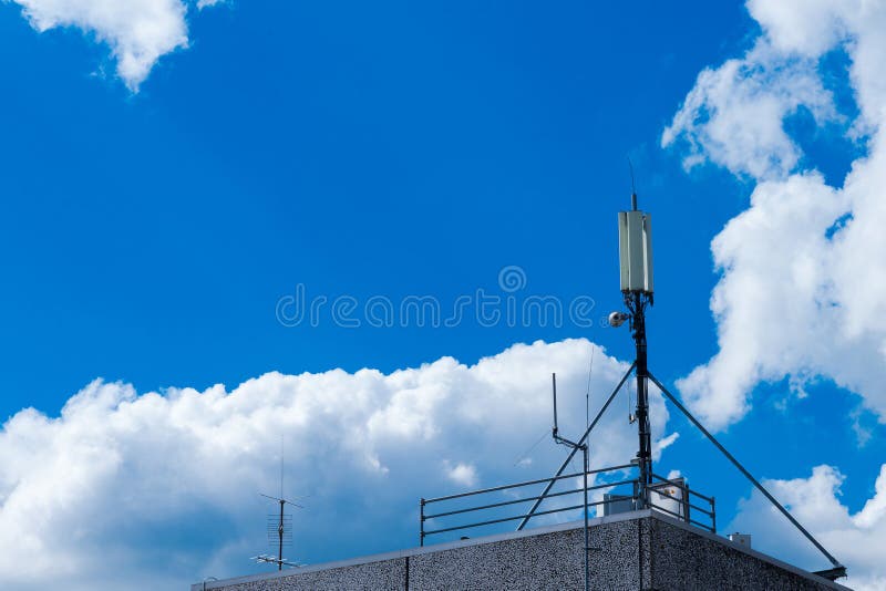Communication Antenna on Building Rooftop Under Blue Sky Stock Photo ...