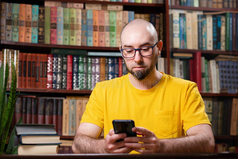 Communication A Bald Smiling Man With Glasses Uses A Smartphone In