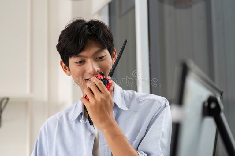 Communication in Construction. Young Engineer Using Walkie-talkie for ...