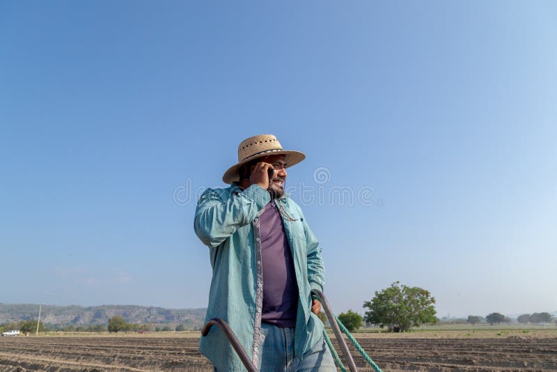Communication in the Field: Modern Farmer Making a Phone Call in the ...