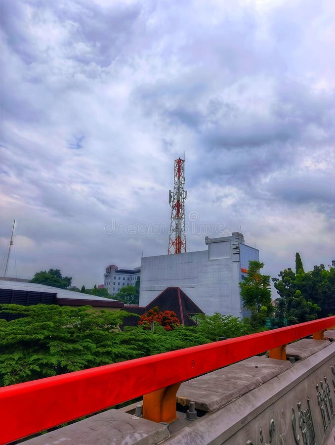Communication Network Tower on Top of Building with Cloudy Sky ...