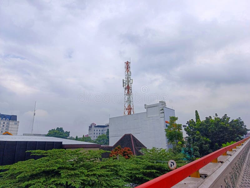 Communication Network Tower on Top of Building with Cloudy Sky ...