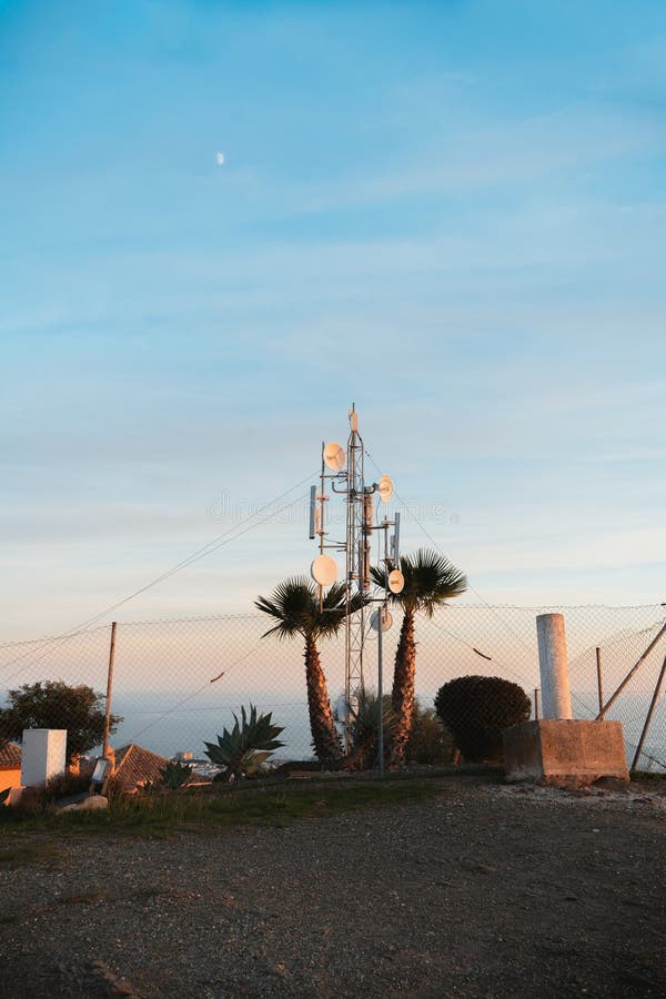 A Communication Tower Stands Surrounded by Nature Under a Vast, Clear ...