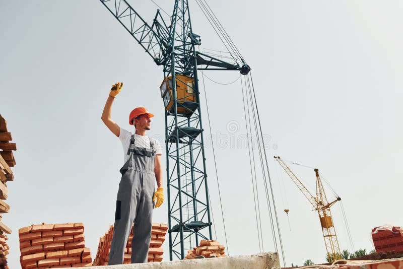 Communicationg with Someone. Young Construction Worker in Uniform is ...