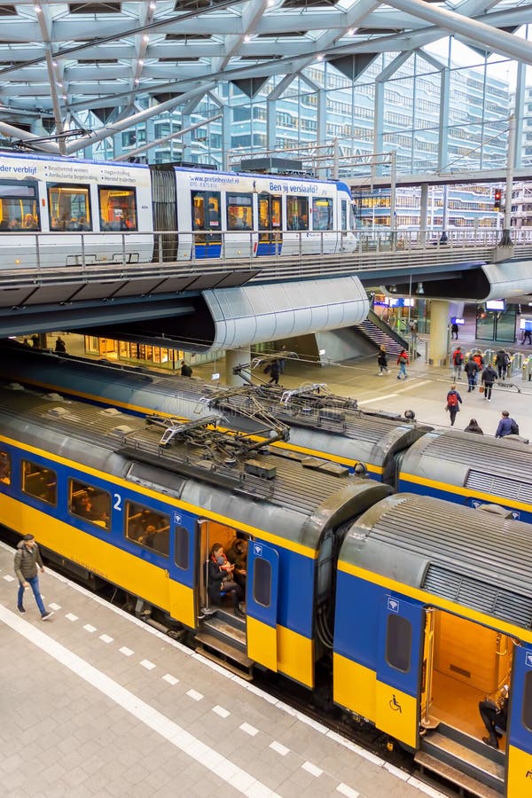 Commuters Waiting on Trains and Trams on a Two Level Station Platform ...