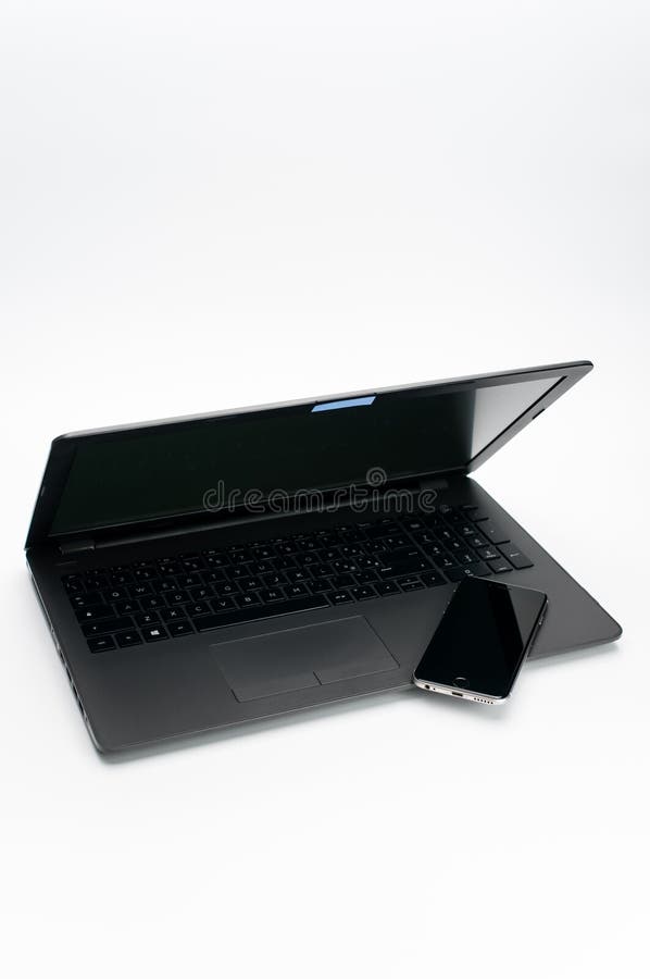Dark Gray Laptop Computer and Smartphone on a White Tabletop Editorial ...