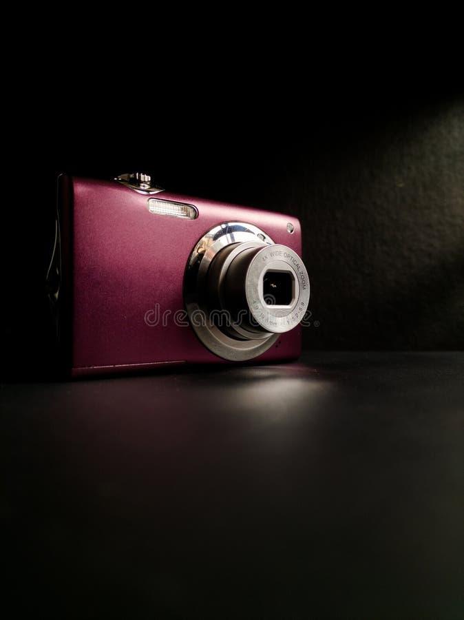 A Compact Digital Camera on Dark Surface Stock Photo - Image of purple ...