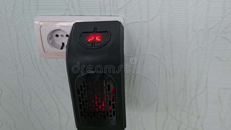 Compact Electric Heater Mounted on a Wall Outlet for Efficient Heating ...