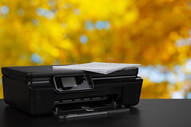 Compact Laser Printer on Black Desk Against Blurred Background Stock ...