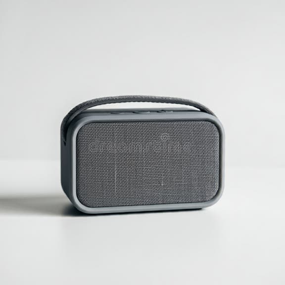 A Compact, Rectangular Bluetooth Speaker with a Soft Gray Fabric Front ...