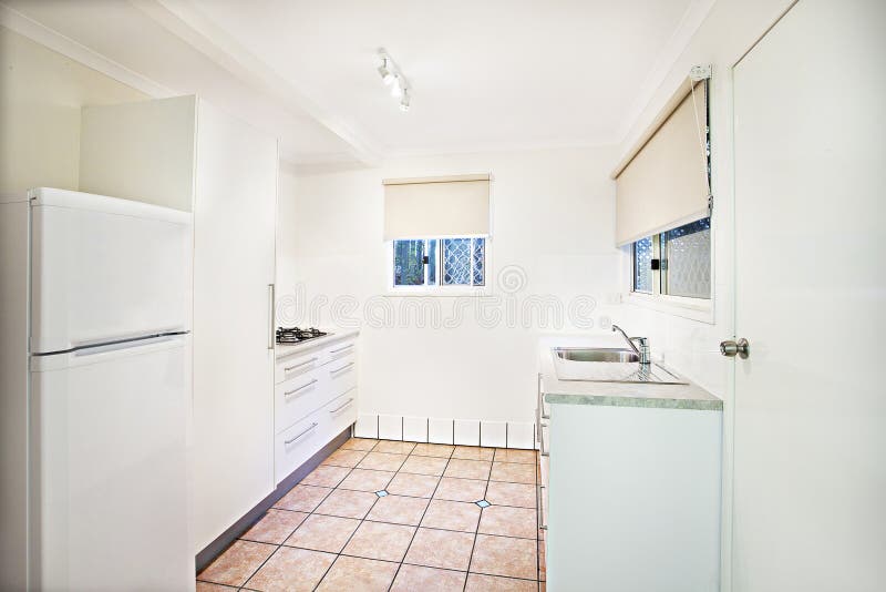 Compact White Fitted Kitchen with Tiled Floor Stock Photo - Image of ...