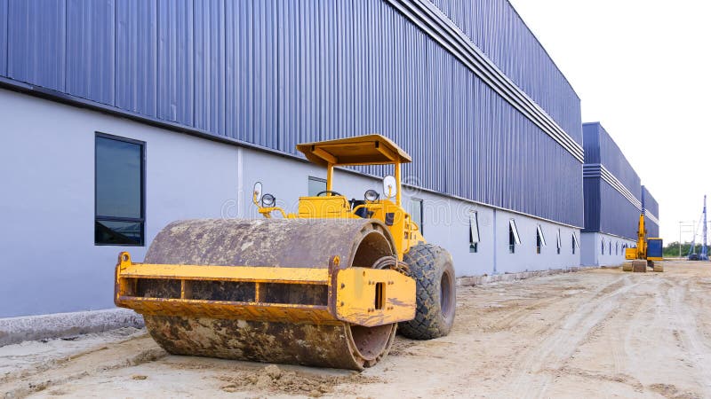 Compactor Roller with Excavator on the Ground beside of Warehouse ...