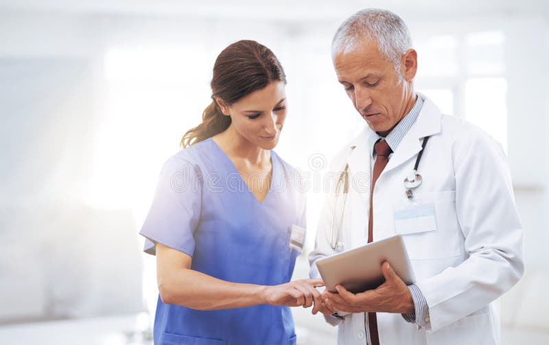 Comparing Medical Records. Shot of Two Medical Professionals Looking at ...