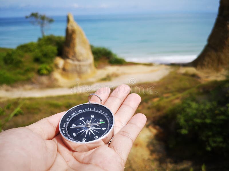 Holding On A Compass Showing Your Direction And Your Navigation By Facing To The Ocean Stock