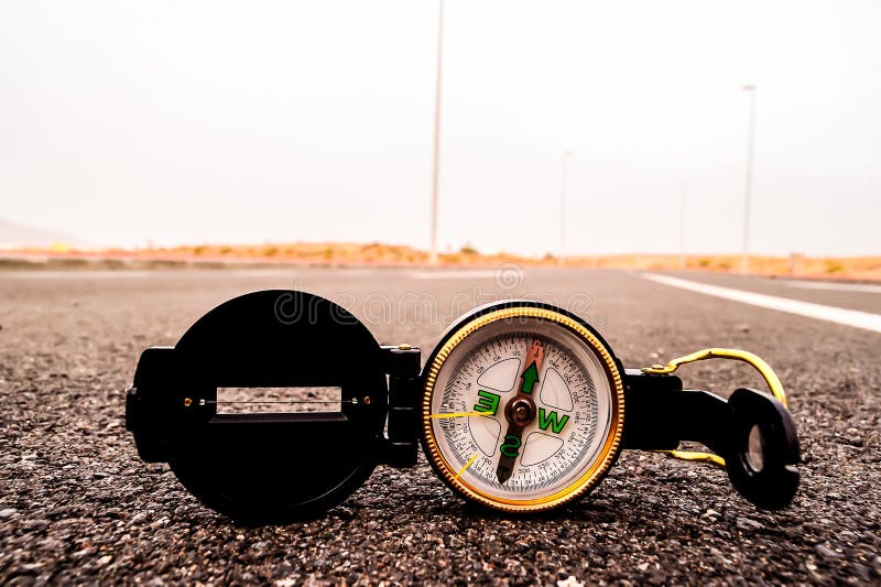 A Compass is Laying on the Ground in Front of a Road Stock Photo ...