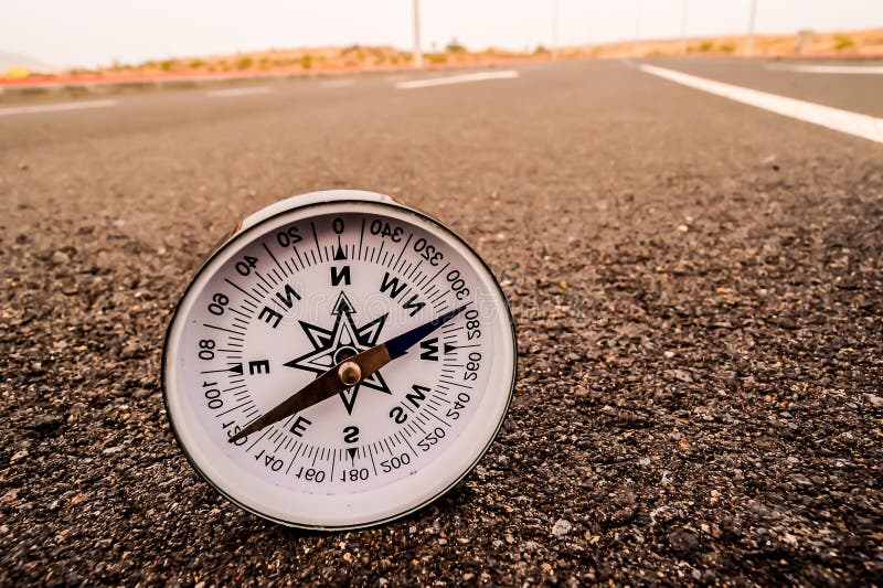 A Compass is Laying on the Ground in Front of a Road Stock Image ...