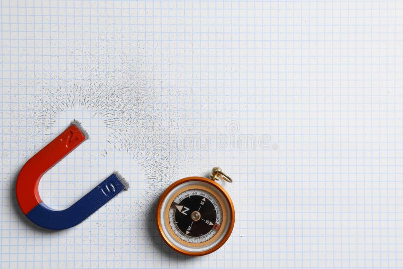 Compass and Magnet with Iron Powder on Squared Paper. Space for Text ...