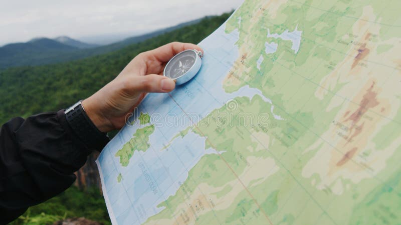 Compass and Map in Hands of Traveler for Checking and Searching ...
