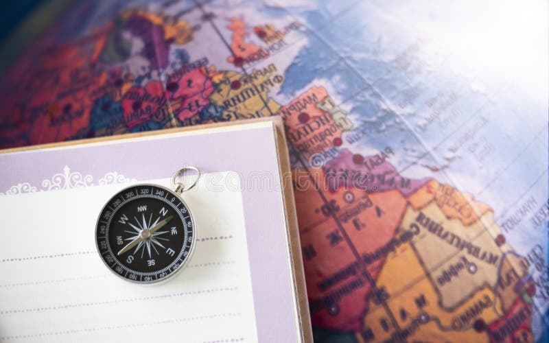 A Compass Placed on a Notebook on the Map Background Stock Photo ...