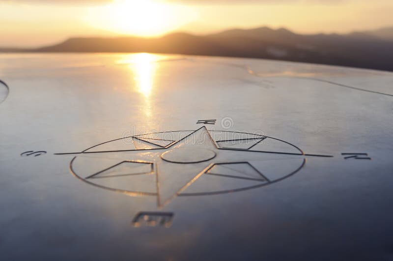 Compass sign at sunset stock image. Image of graved, grave - 24719059