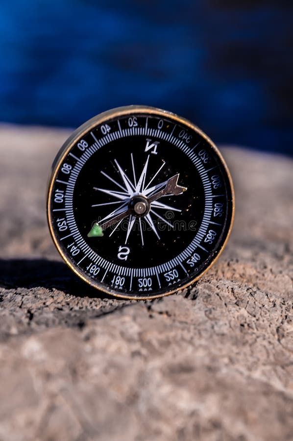 A Compass is Sitting on a Rock Stock Image - Image of navigation, gold ...