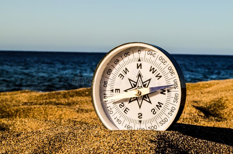 A Compass is Sitting on the Sand Next To the Ocean Stock Image - Image ...